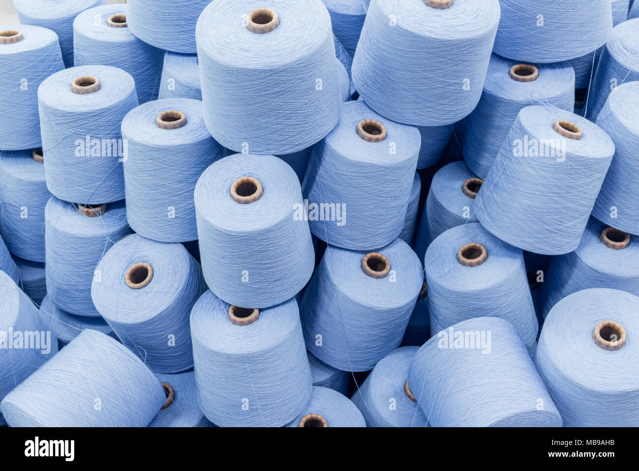 a large pile of spools of blue thread. close up Stock Photo - Alamy