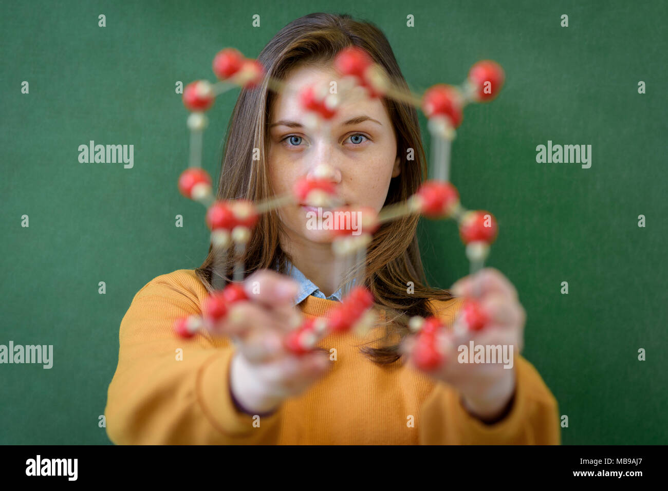 Female student holding molecular structure model. Science class concept ...