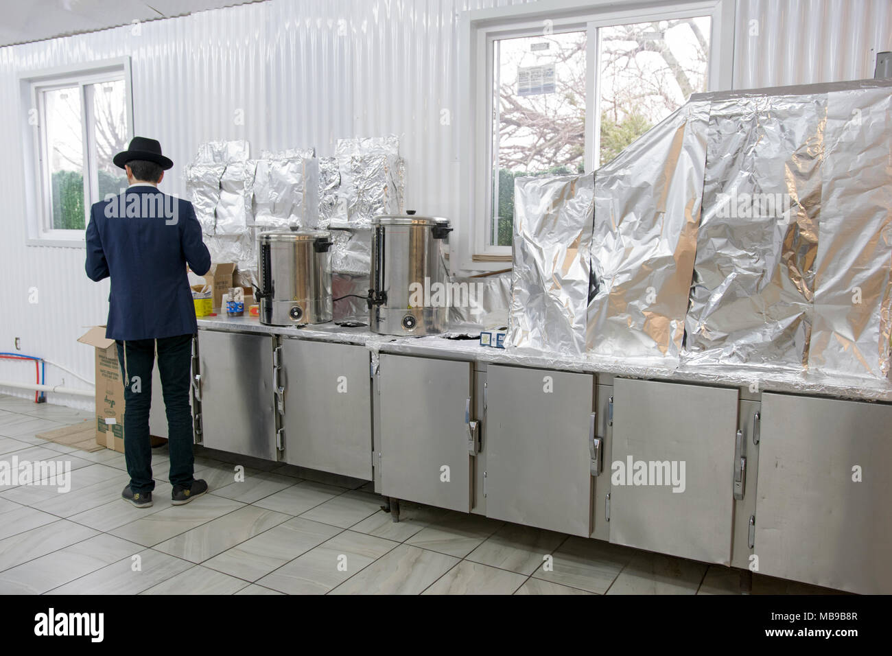 A religious Jewish man makes coffee at the Ohel during Passover which ...