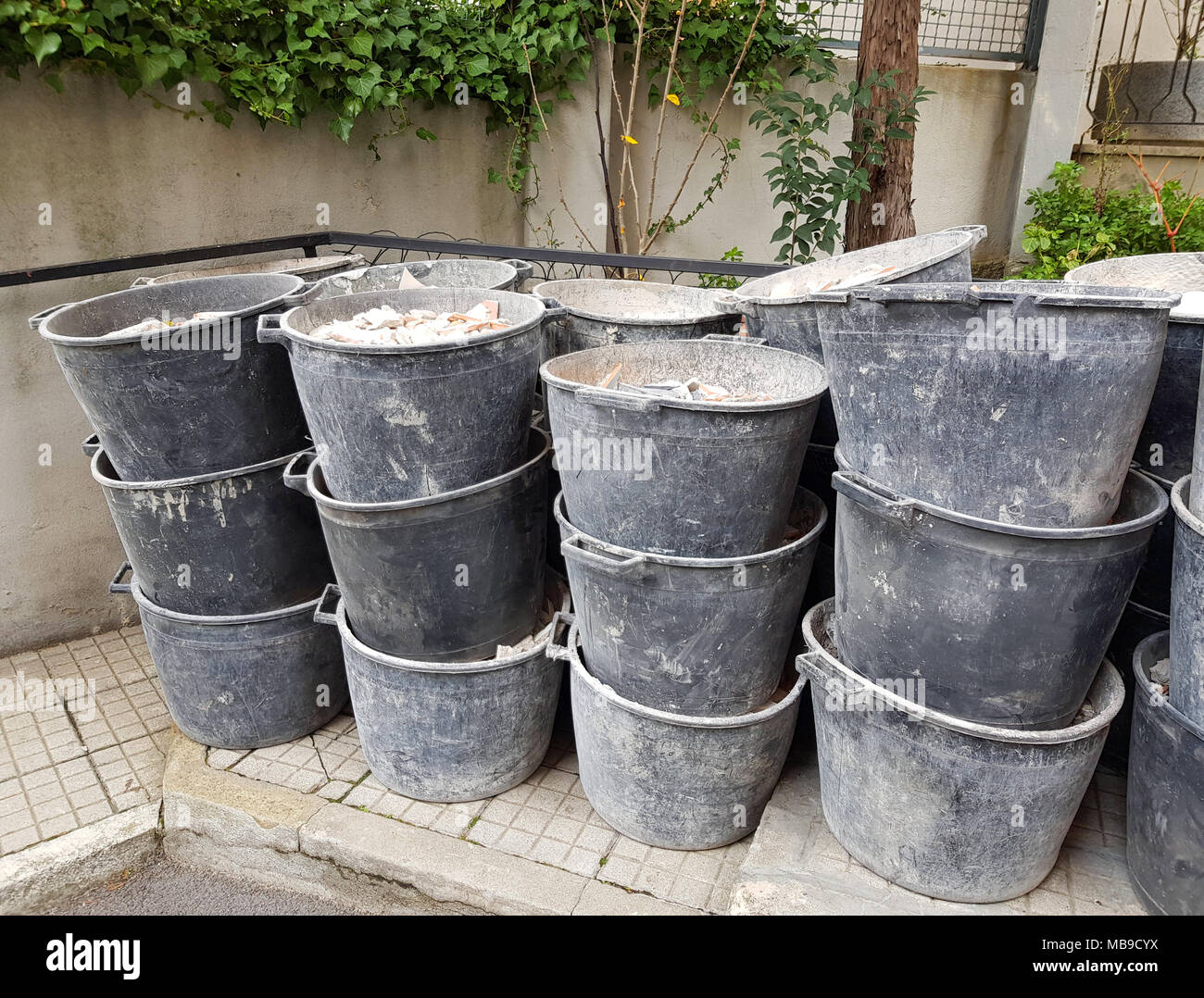 Pile of plastic construction buckets on construction site background ...