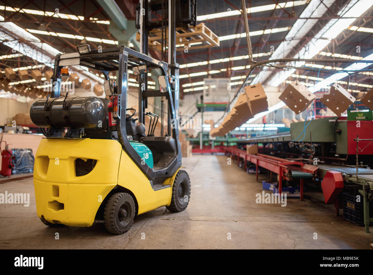 The forklift is in a large and light warehouse. Yellow color Stock ...