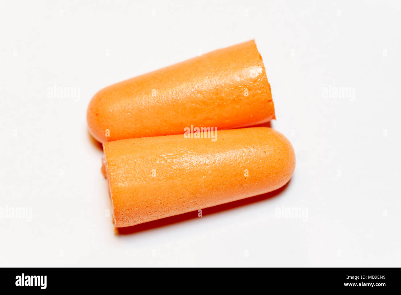 two orange ear plugs on a white background Stock Photo - Alamy