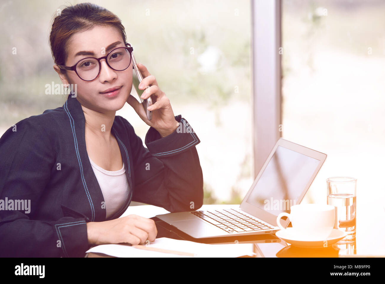 Beautiful Asian business woman holding smart phone and calling, office ...