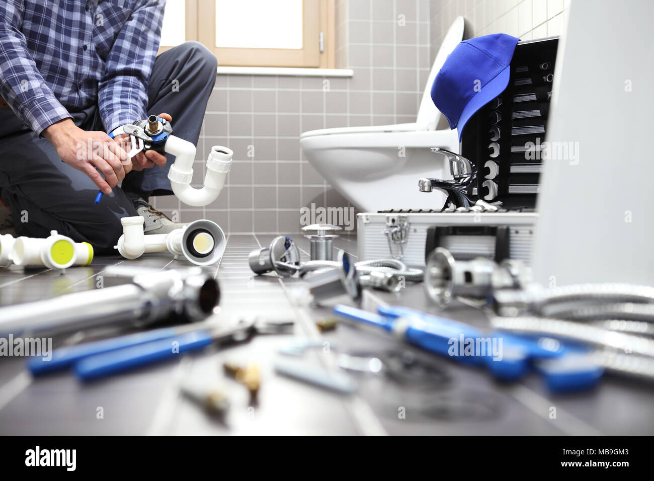 plumber at work in a bathroom, plumbing repair service, assemble and ...