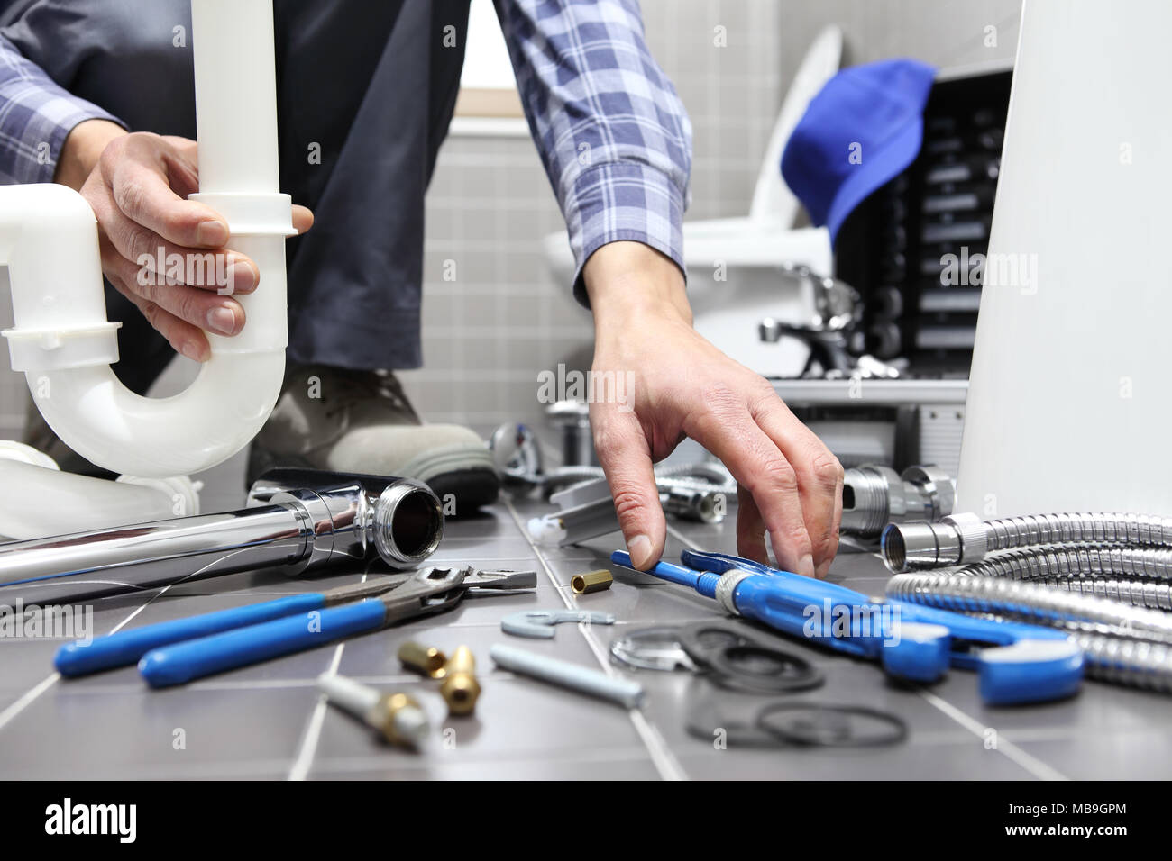 plumber at work in a bathroom, plumbing repair service, assemble and ...