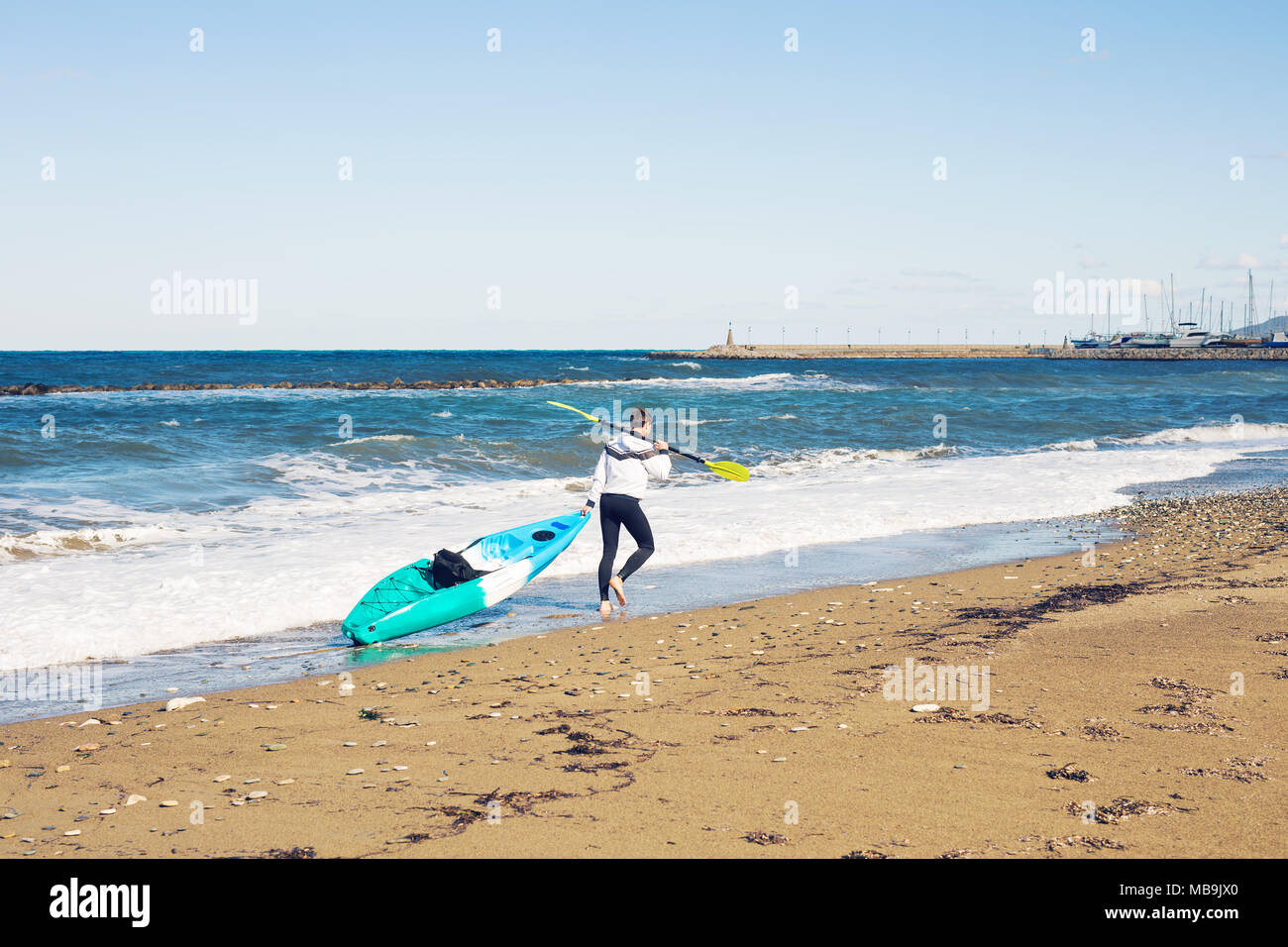 man carrying kayak at sea beach Stock Photo - Alamy