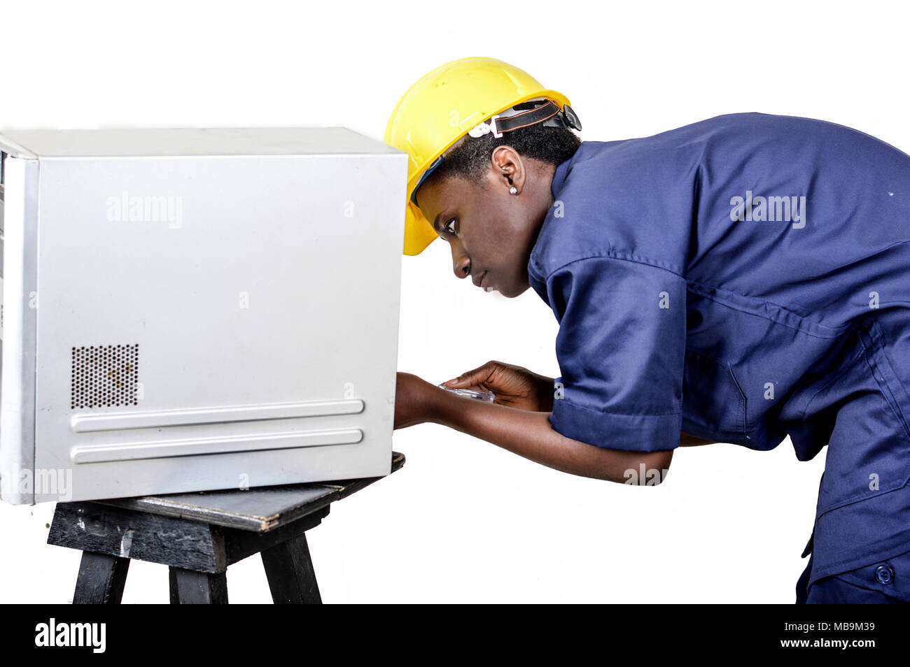 Young African woman in computer maintenance opens the central unit with ...