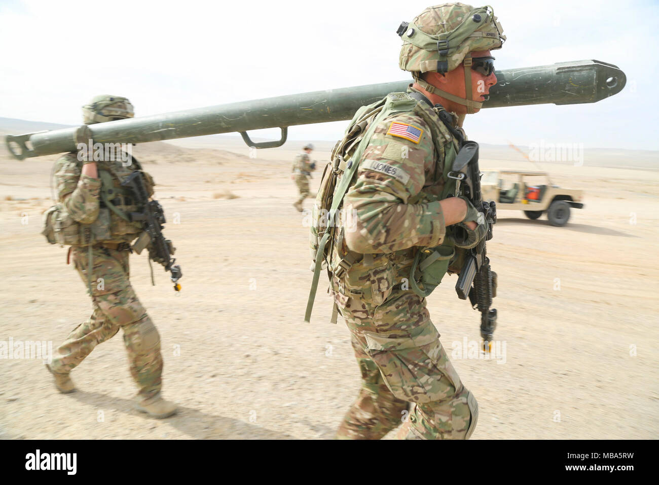 U.S. Army Soldiers assigned to 3rd Cavalry Regiment carry a tow bar to ...