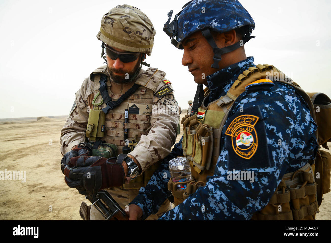 A Spanish trainer assist an Iraqi soldier attached to 1st Battalion ...