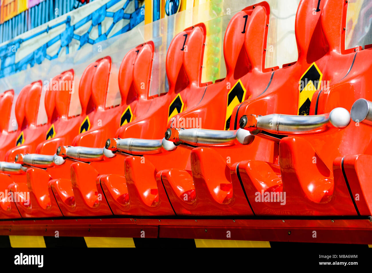 Row of empty vivid red seats of a thrilling ride in a funfair Stock ...