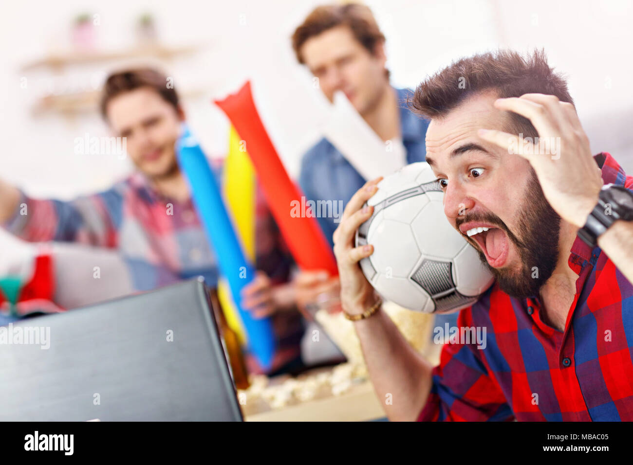 Happy male friends cheering and watching sports on tv Stock Photo - Alamy