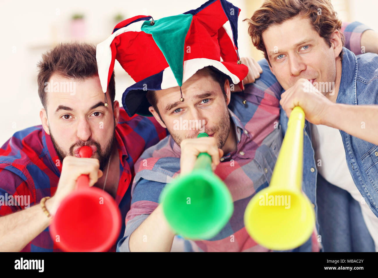Happy male friends cheering and watching sports on tv Stock Photo - Alamy