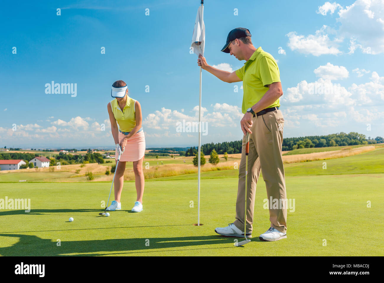 Female golf player ready to hit the ball under the instruction of her ...