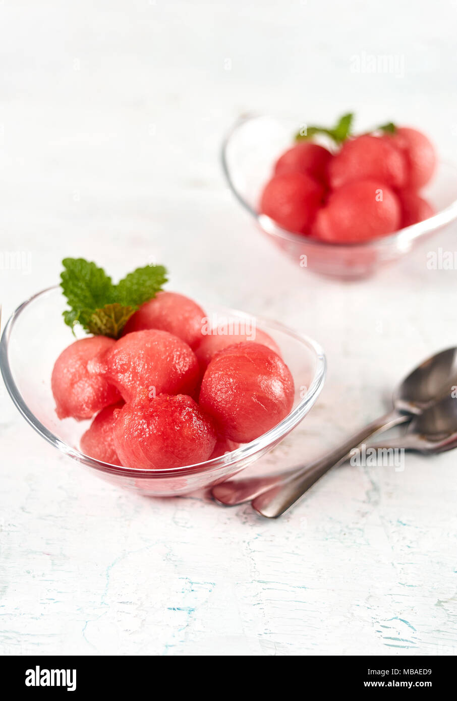 Watermelon cut in small balls and served in glass dishes on wooden ...