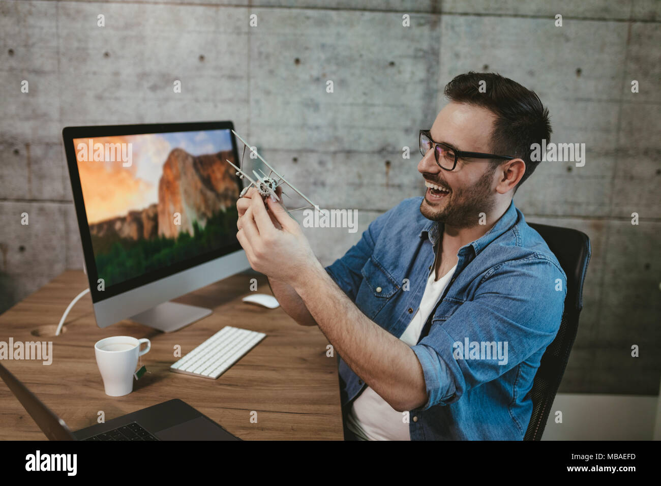 Young handsome successful freelance entrepreneur having fun and showing ...