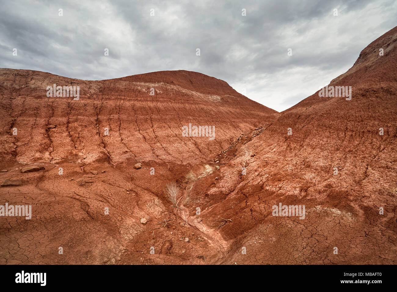 Red striped mountains at overcast sky in desert park Altyn Emel in ...