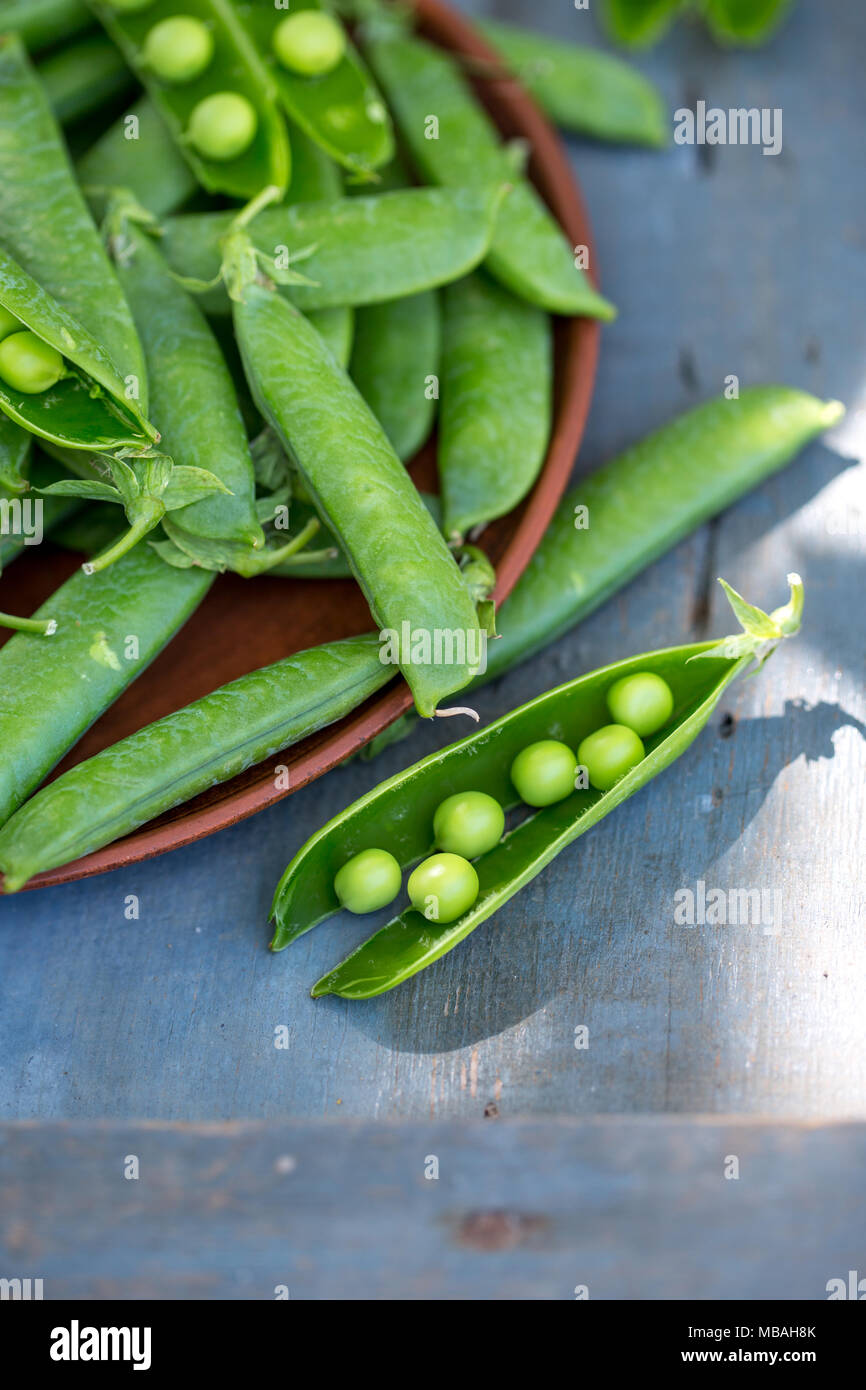 Green pea in plate on rustic wooden background Stock Photo - Alamy