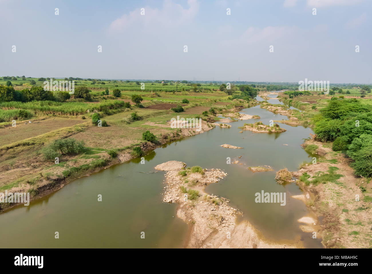 A small river Channel below a bridge with farming land Stock Photo - Alamy