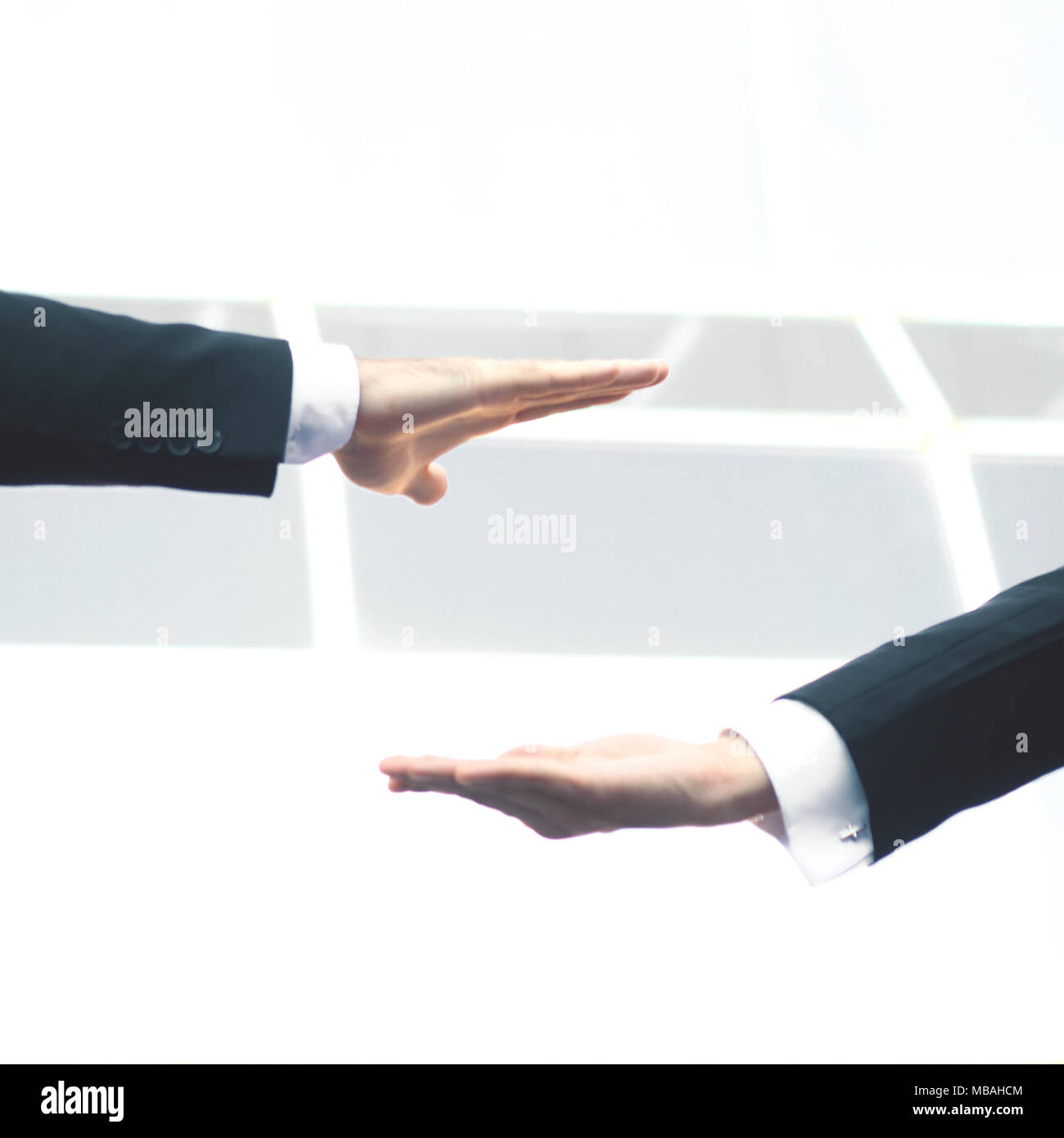 close up.two businessmen stretching out their hands towards each other ...