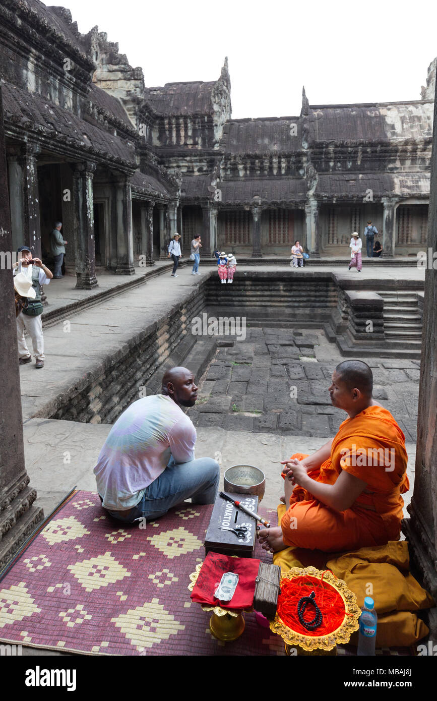 Angkor Wat monk - a monk talking with people and giving blessings ...