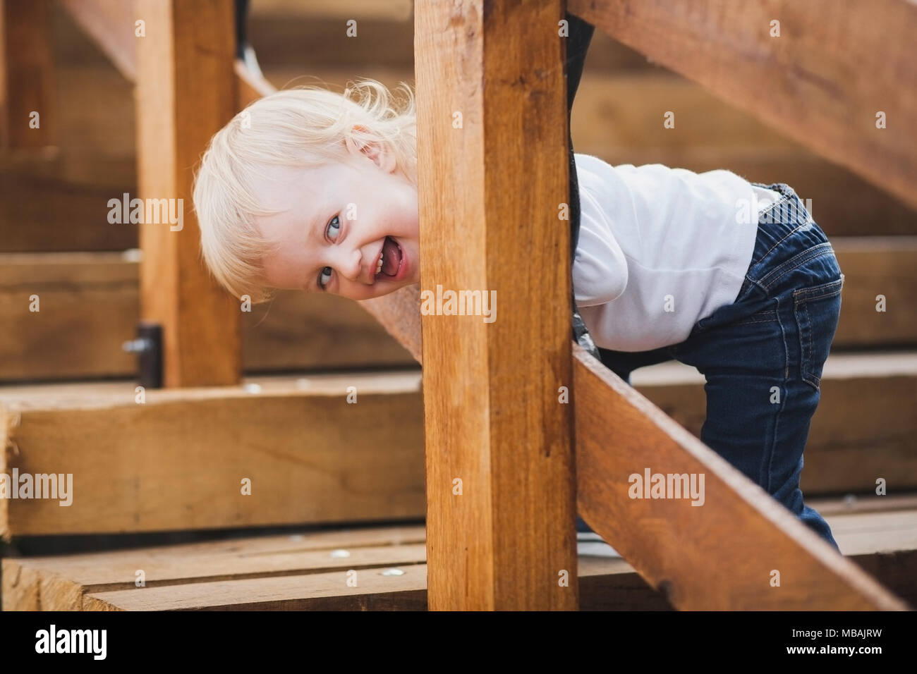 1 year old little caucasian girl palaing hide and seek game outdoors on ...