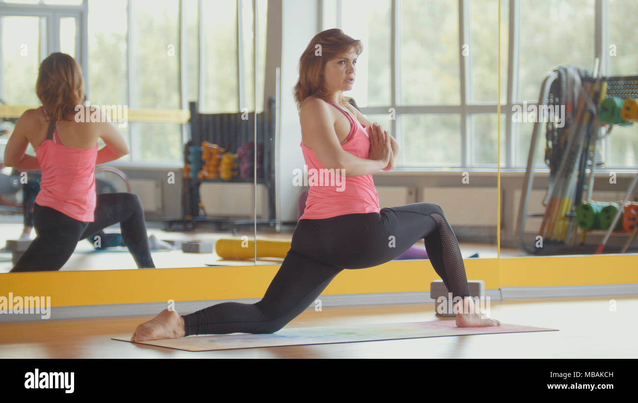 Attractive fitness coach stretching out in a gym Stock Photo - Alamy