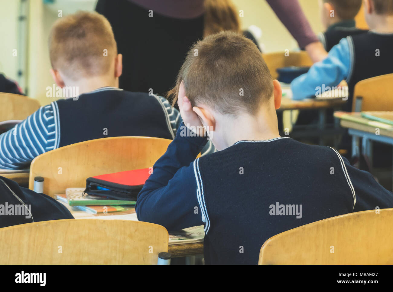 Tired pupil in class at school. Back view Stock Photo - Alamy