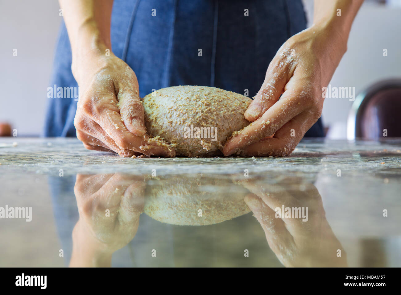 Female hands knead whole wheat dough, made of common flour and ...
