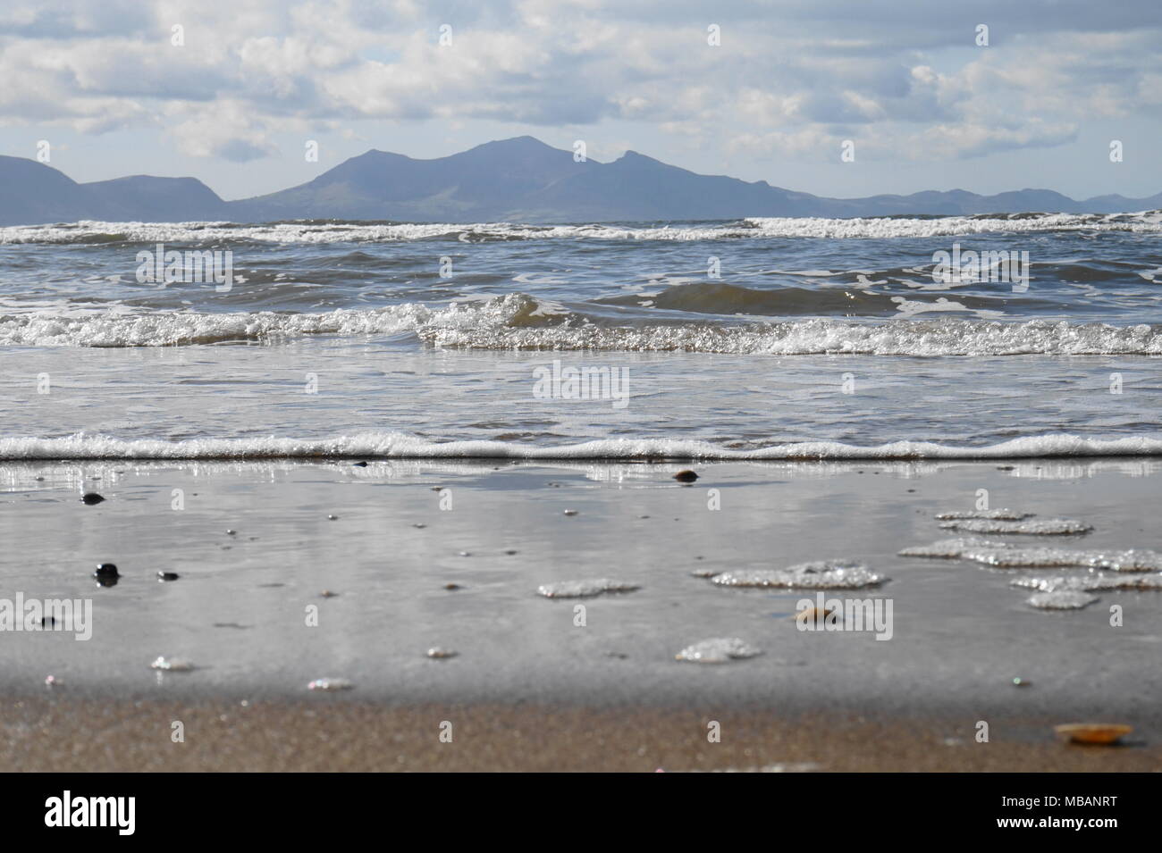 Beautiful transparent water on the shoreline with Welsh Mountains ...