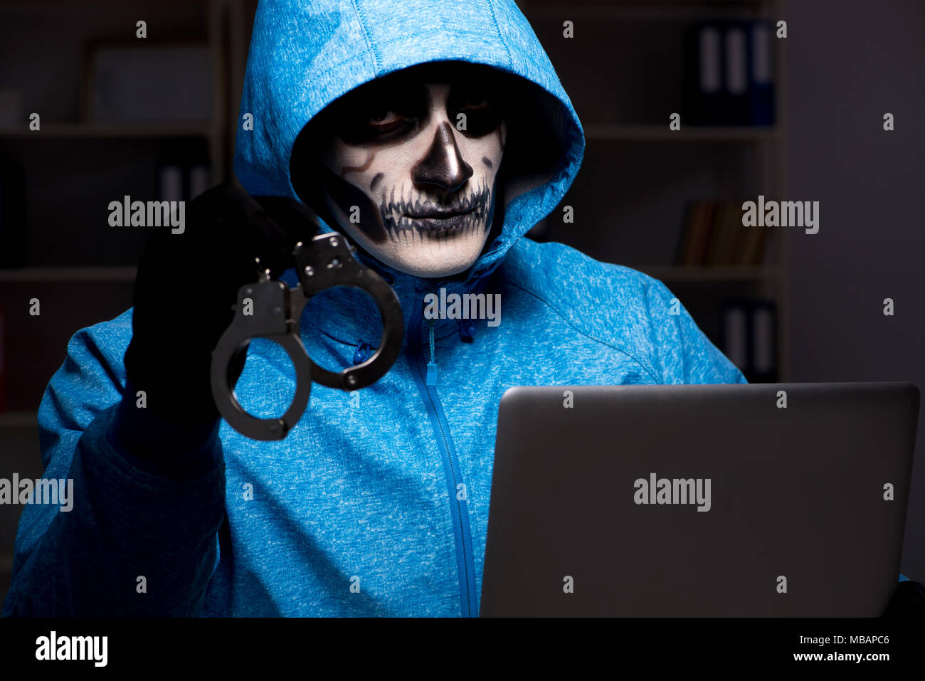 Scary hacker hacking security firewall late in office Stock Photo - Alamy