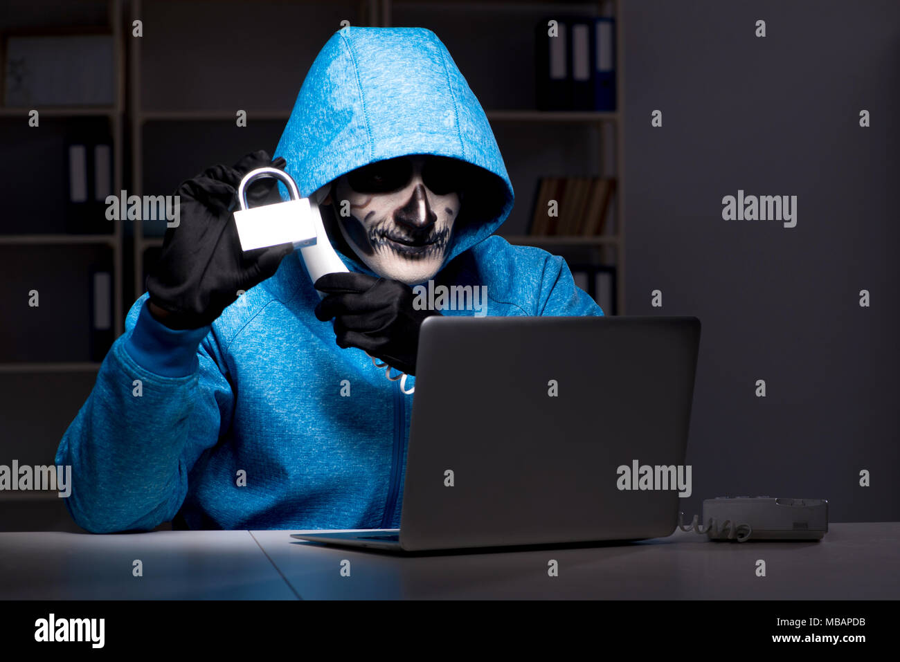 Scary hacker hacking security firewall late in office Stock Photo - Alamy