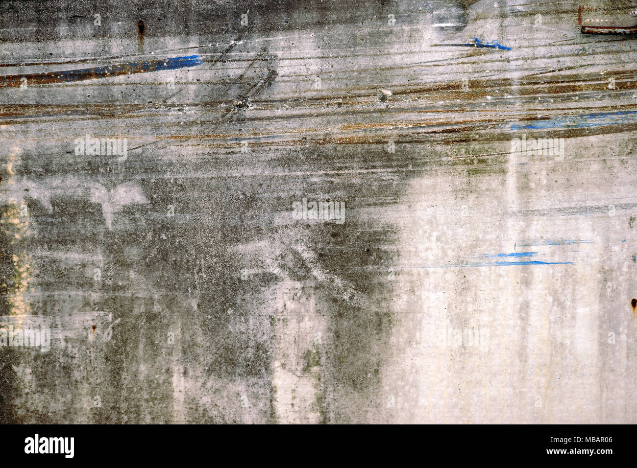 The concrete side wall of a loading ramp with scratch marks and paint ...