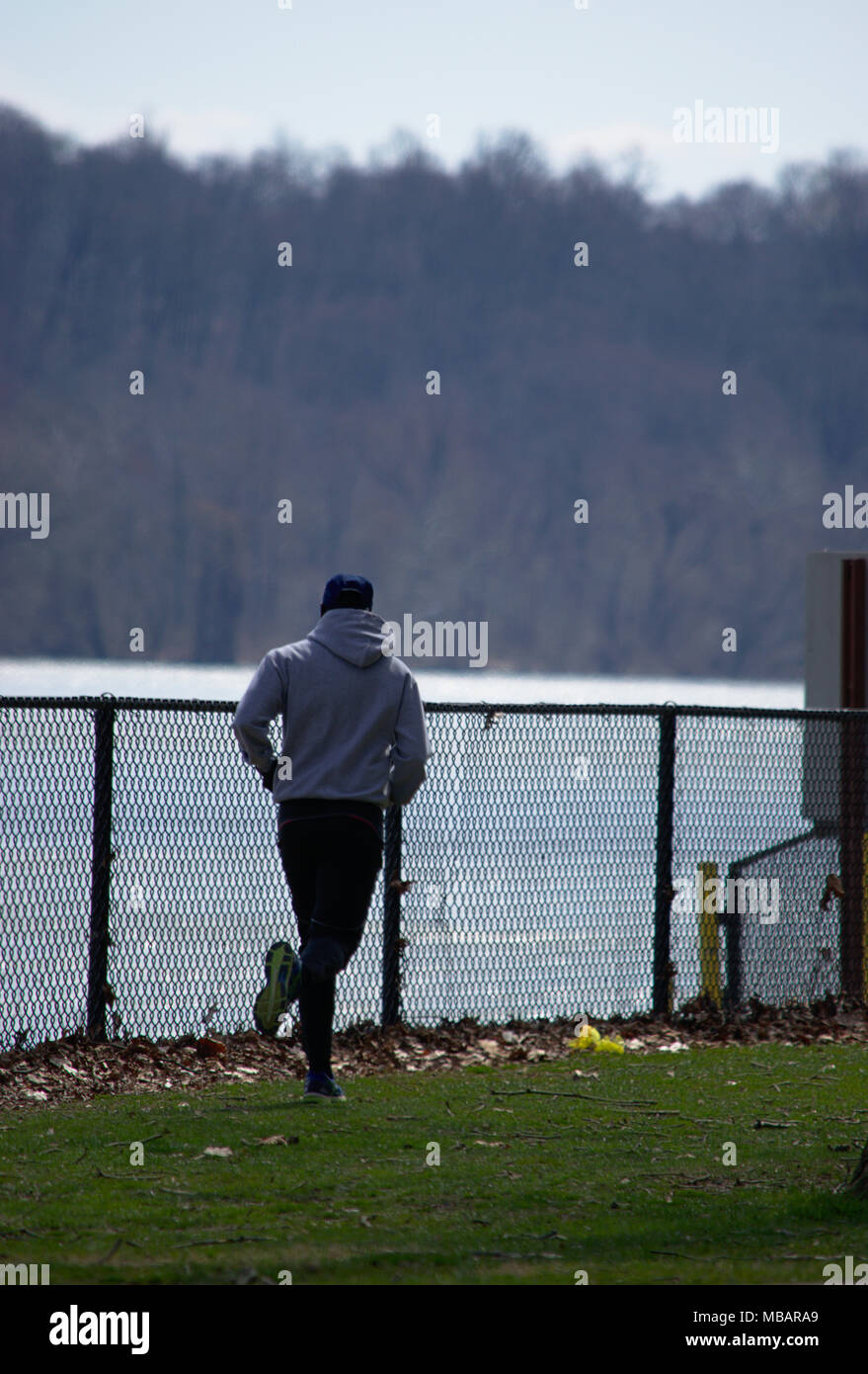 Young man jogging near river Stock Photo - Alamy
