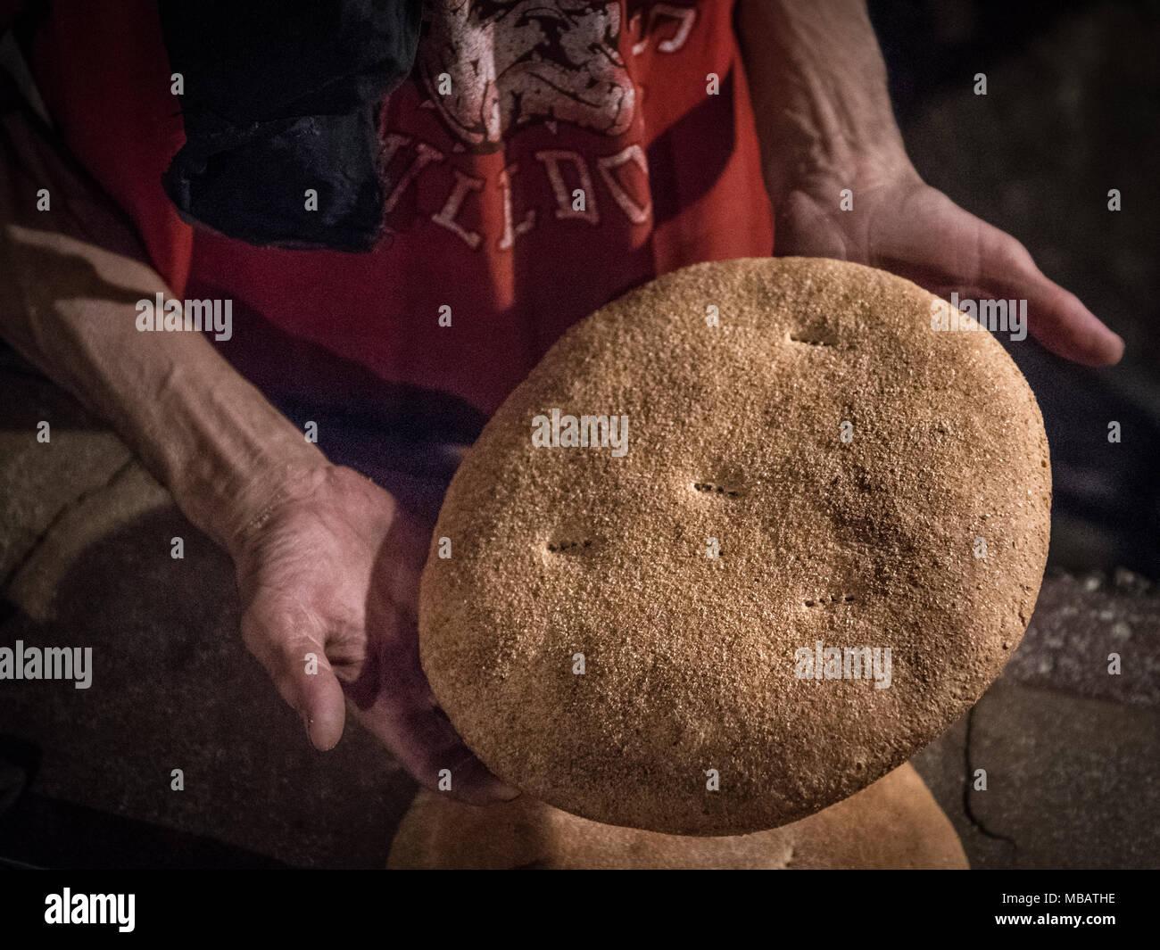 A Moroccan baker shows off a round loaf of traditional Moroccan bread ...