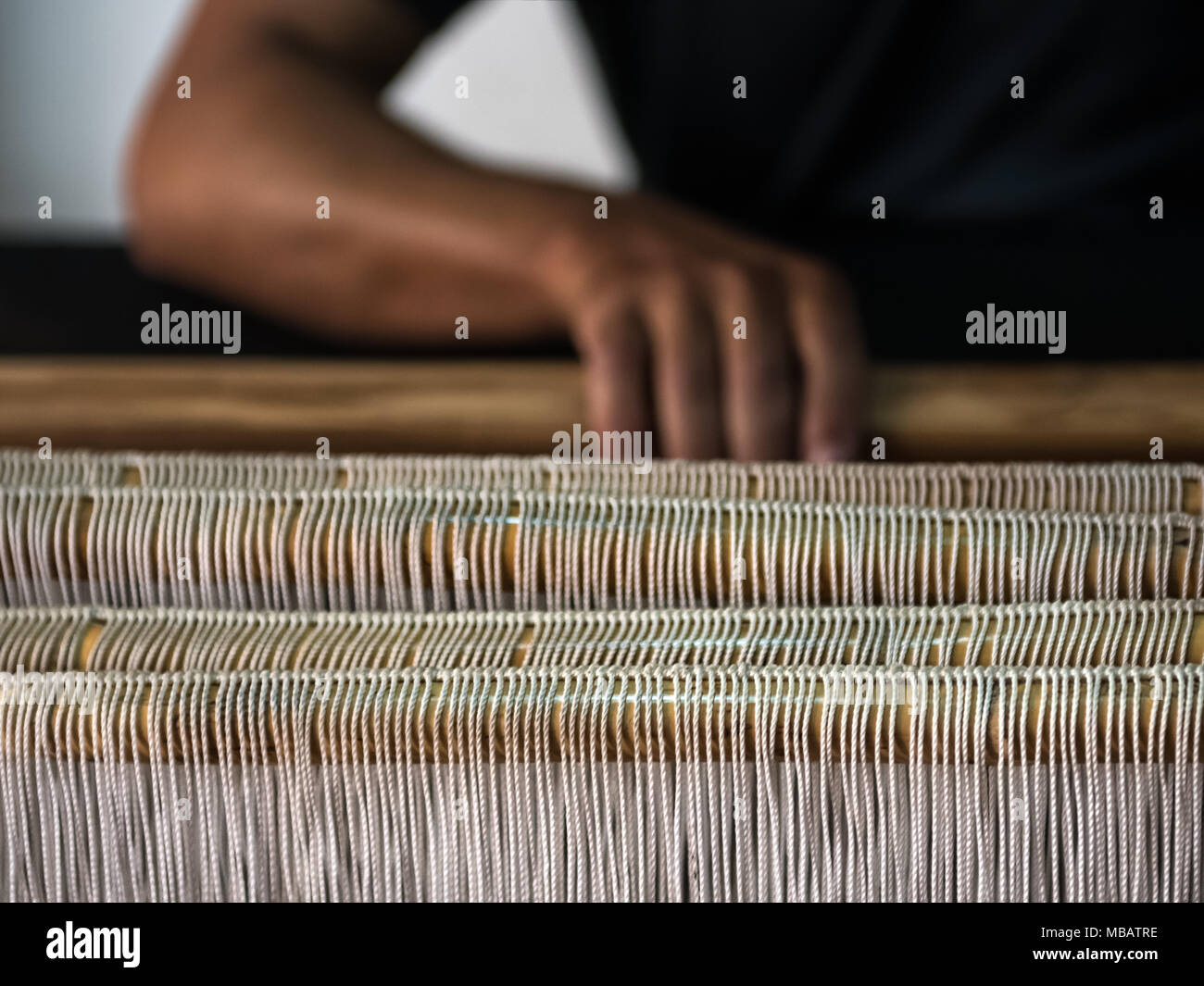 A weaver demonstrates weaving on his loom in a souk in Marrakech ...
