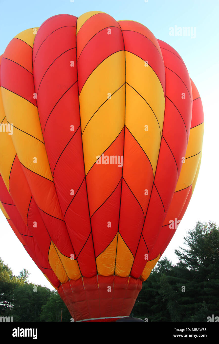bright orange and yellow hot air balloon against a clear blue sky Stock ...