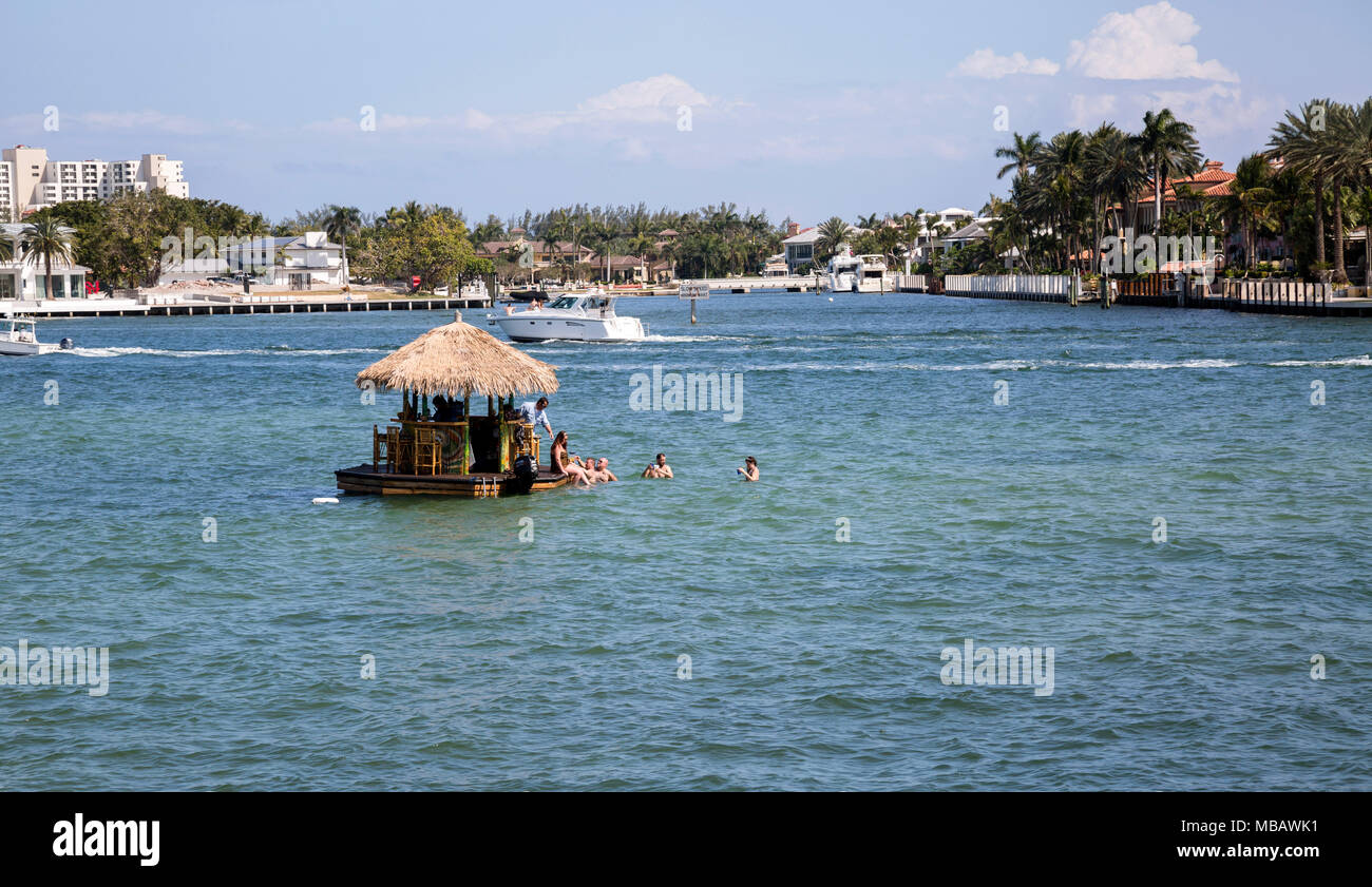 Young people at a floating tiki hut, having drinks on vacation in Fort ...