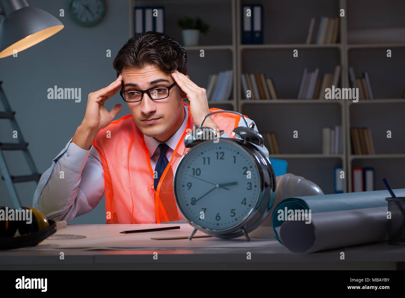 Tired architect working late long hours under stress to meet deadline ...