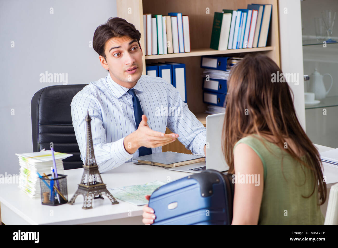 Customer visiting travel agency and talking to agent Stock Photo - Alamy