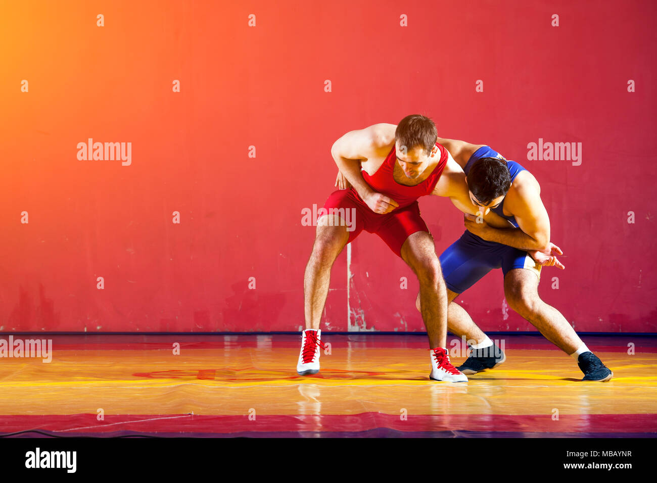 Two strong wrestlers in blue wrestling tights are wrestlng and making a ...