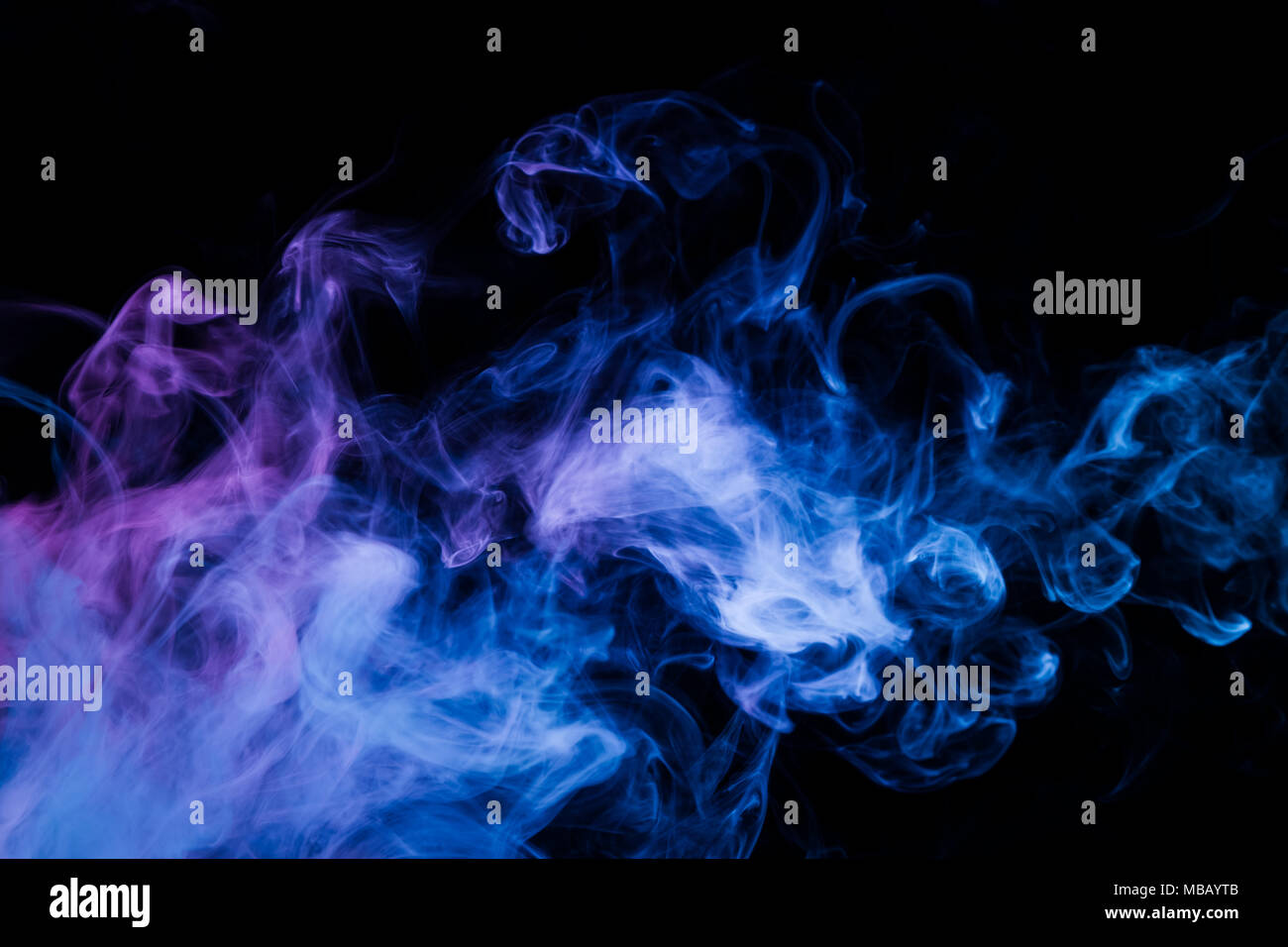 Dense multicolored smoke of blue colors on a black isolated background ...