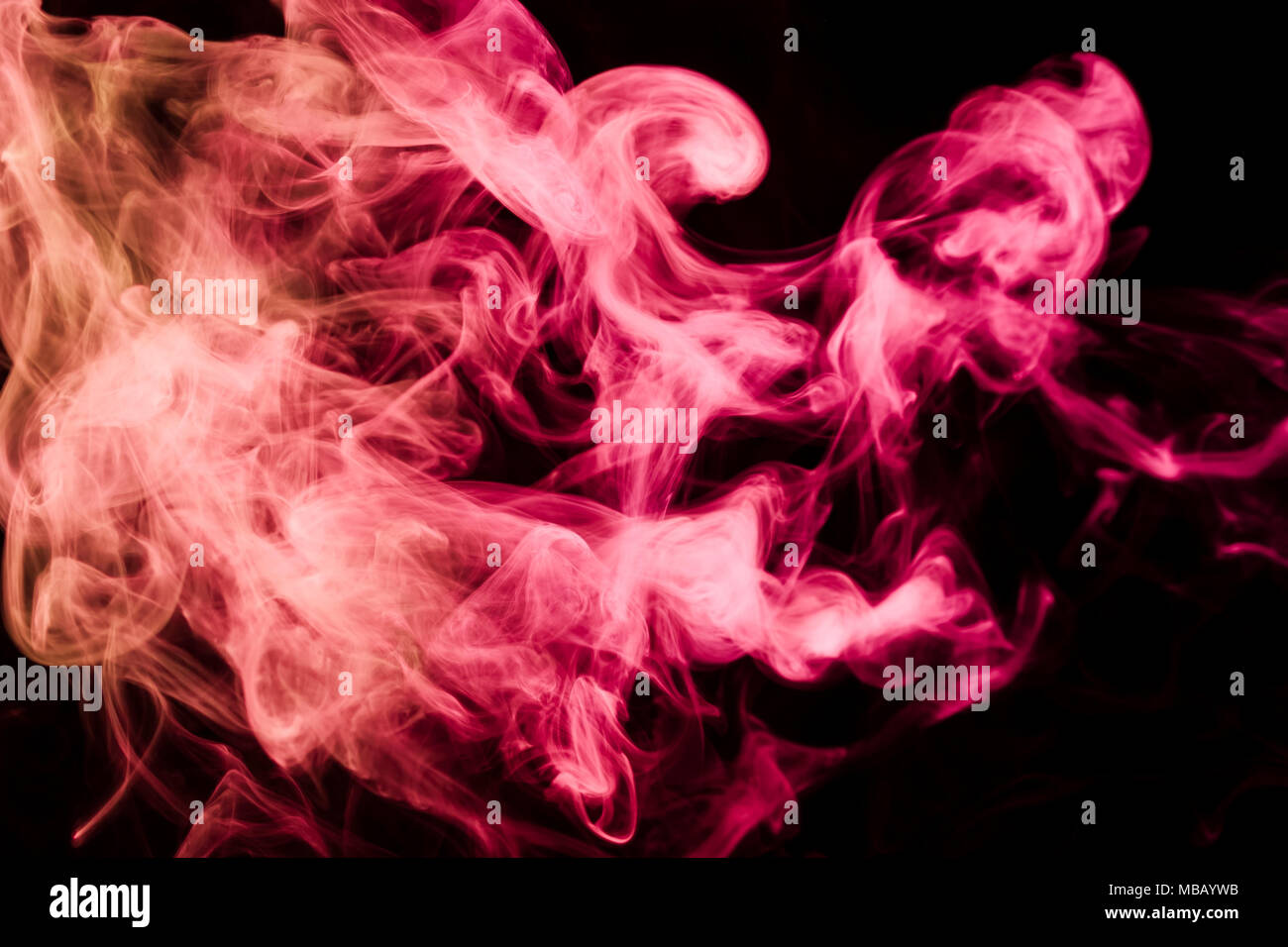 Thick pink and red colorful smoke on a black isolated background ...