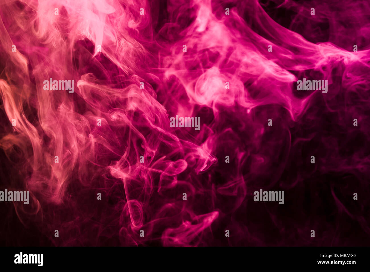 Thick pink and red colorful smoke on a black isolated background ...