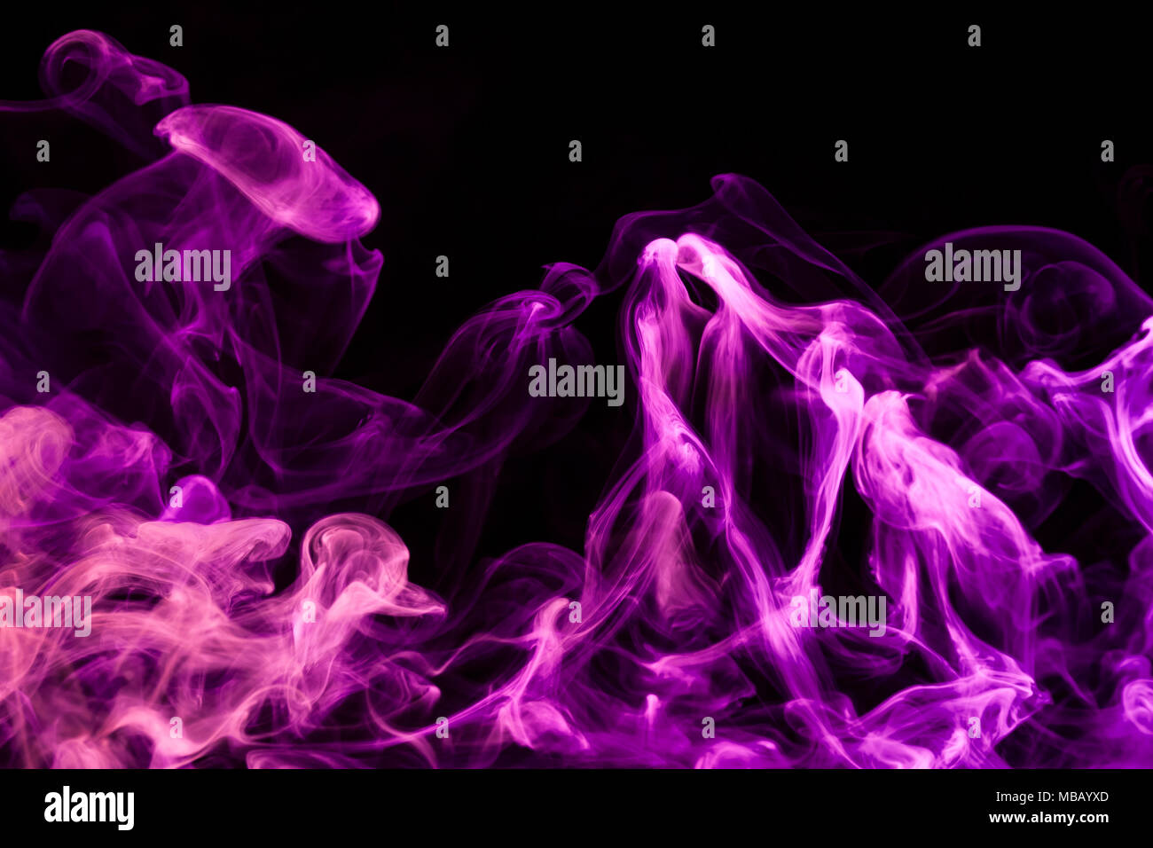 Thick pink and red colorful smoke on a black isolated background ...