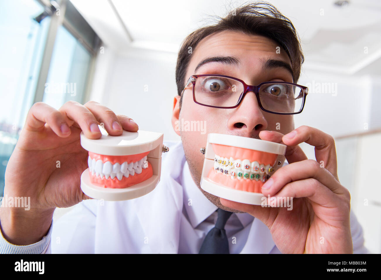 Funny dentist with teeth model in hospital Stock Photo - Alamy