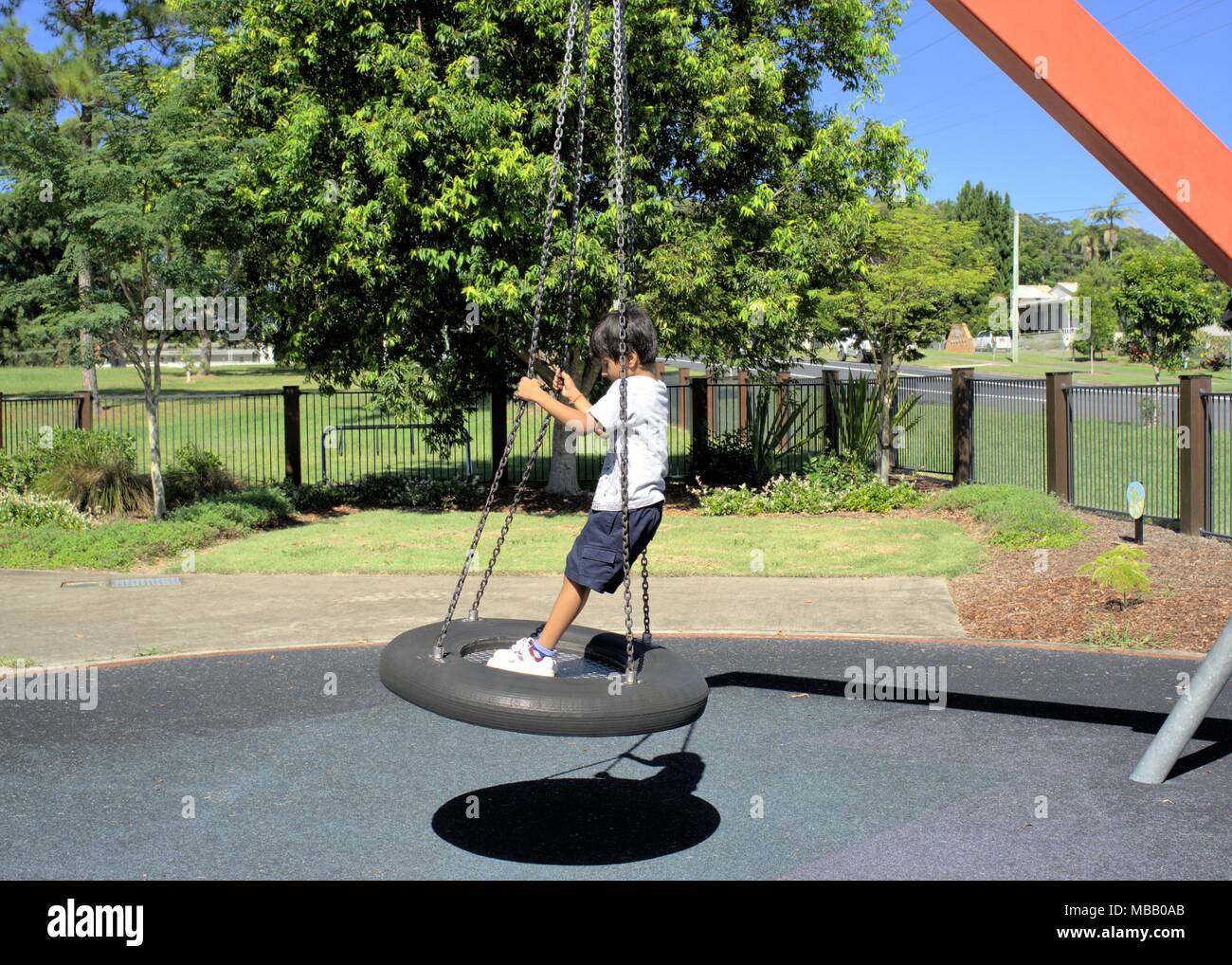 Kid playing in park. Child playing on swing in park. Boy on swing Stock ...