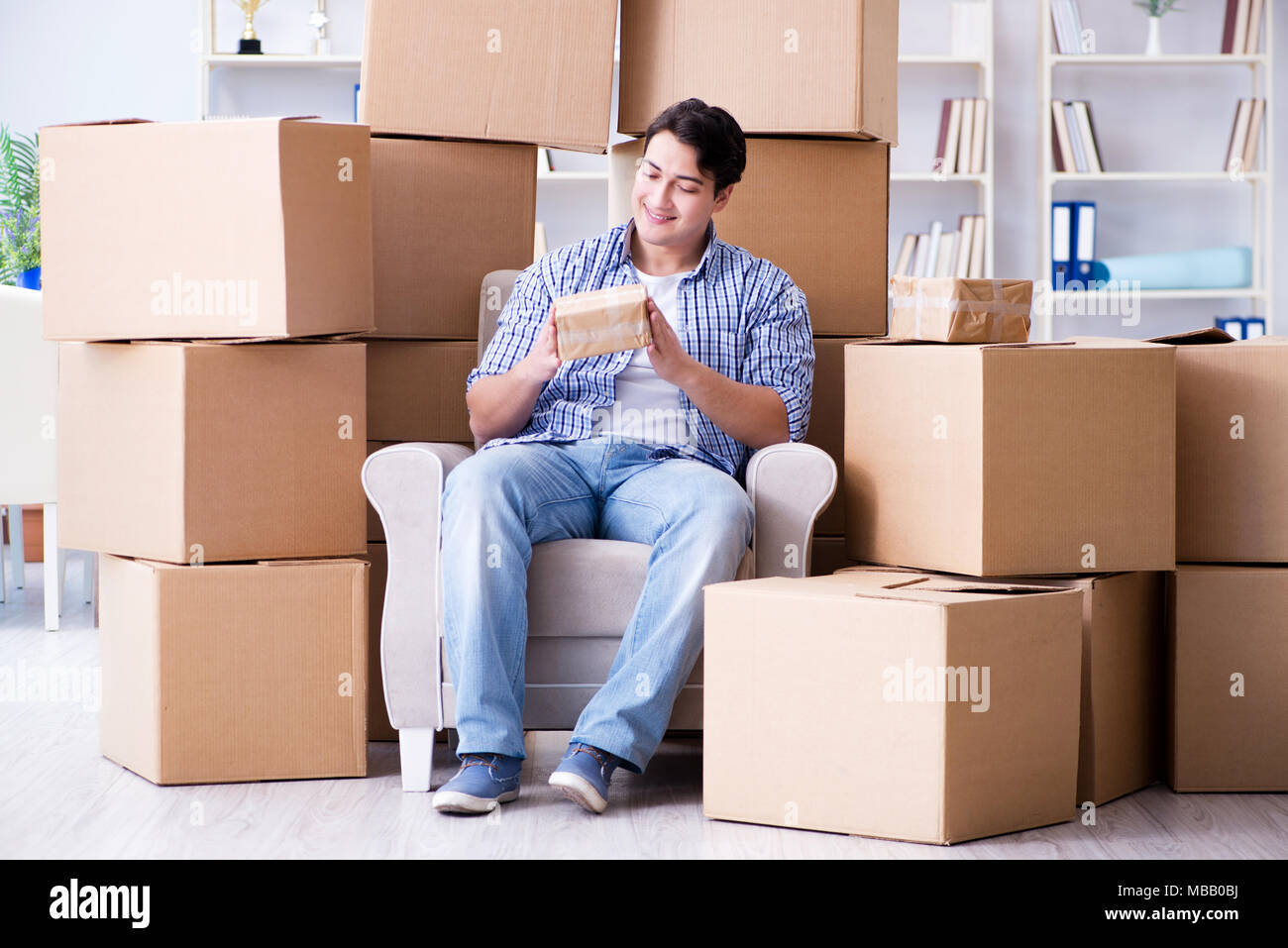 Young man moving in to new house with boxes Stock Photo - Alamy
