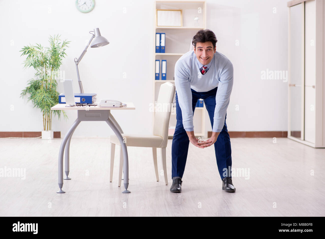Employee doing stretching exercises in the office Stock Photo - Alamy