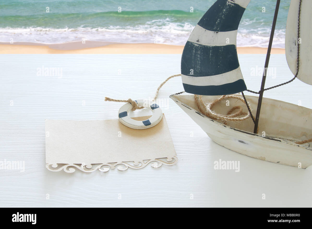 nautical concept image with white decorative sail boat with note over ...