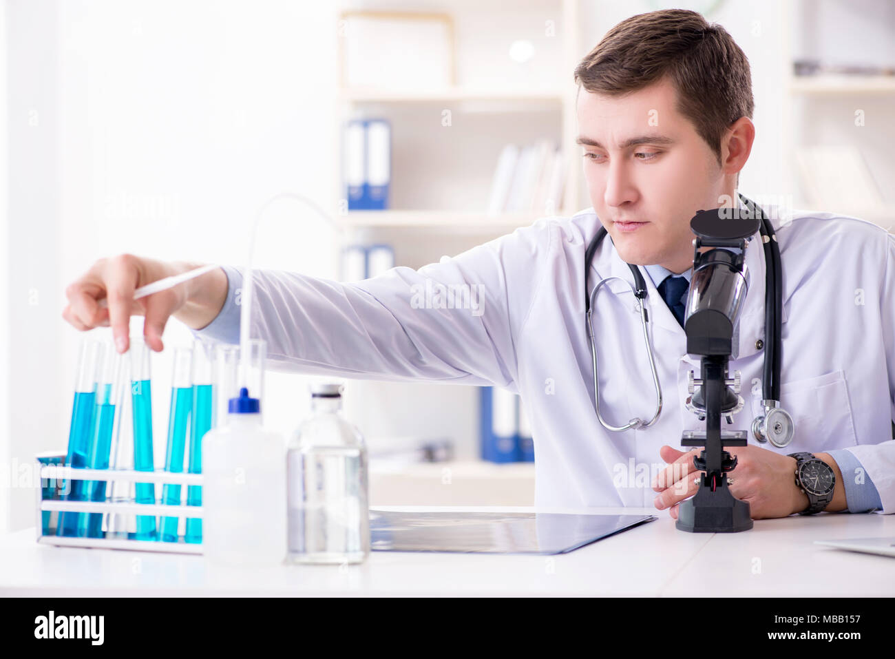 Male doctor looking at lab results in hospital Stock Photo - Alamy